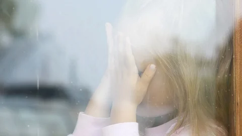 Little girl crying by the window | Stock Video | Pond5
