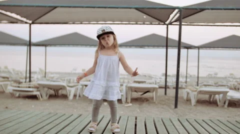 little girl dancing in evening pebble be... | Stock Video | Pond5