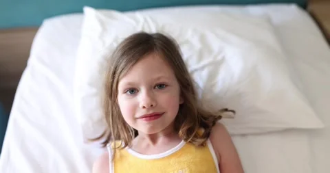 Little girl falling on white bed with pi... | Stock Video | Pond5
