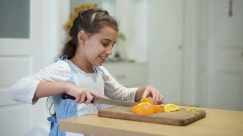 Little girl hands cutting fresh orange o... | Stock Video | Pond5