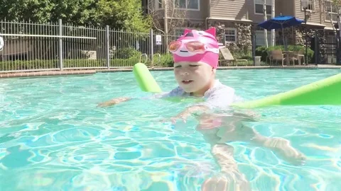 Little girl having fun with swim noodle ... | Stock Video | Pond5