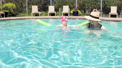 Little girl having fun with swim noodle ... | Stock Video | Pond5
