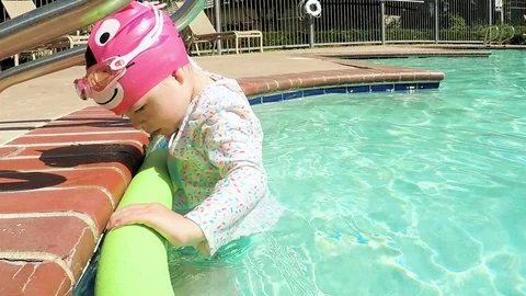 Little girl having fun with swim noodle ... | Stock Video | Pond5