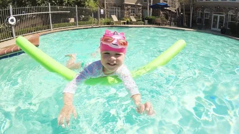 Little girl having fun with swim noodle ... | Stock Video | Pond5