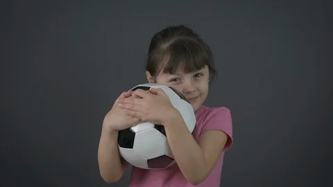 Little girl hugs a soccer ball. | Stock Video | Pond5