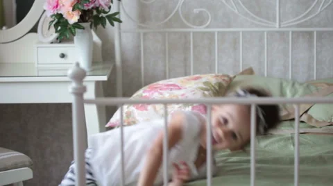 Little girl is jumping on the bed. HD vi... | Stock Video | Pond5