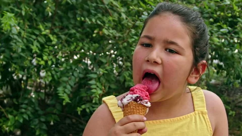 Little Girl Looking at Camera While Eati... | Stock Video | Pond5