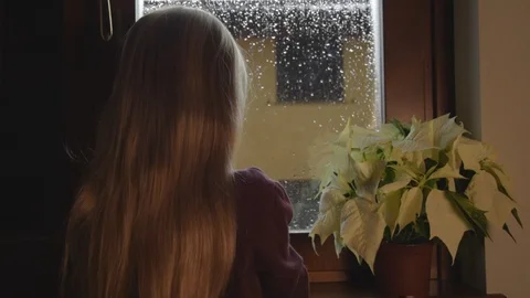 little girl looks outside window on sad ... | Stock Video | Pond5