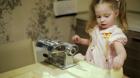 little girl making pasta in the kitchen | Stock Video | Pond5