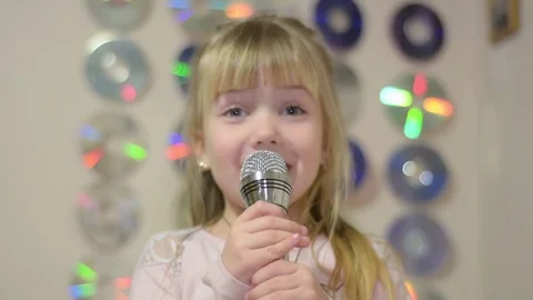 Little girl with microphone sings songs | Stock Video | Pond5