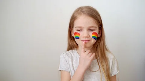 little girl painted cheeks a rainbow. st... | Stock Video | Pond5