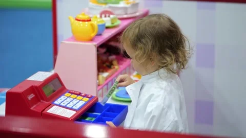 Little girl playing cashier with toy cas... | Stock Video | Pond5