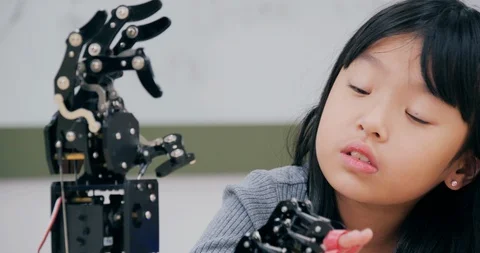 Little Girl is playing with robotic arm ... | Stock Video | Pond5