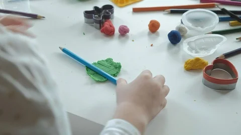 a little girl plays with plasticine, rol... | Stock Video | Pond5