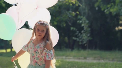 Little girl plays spinning with balloons... | Stock Video | Pond5