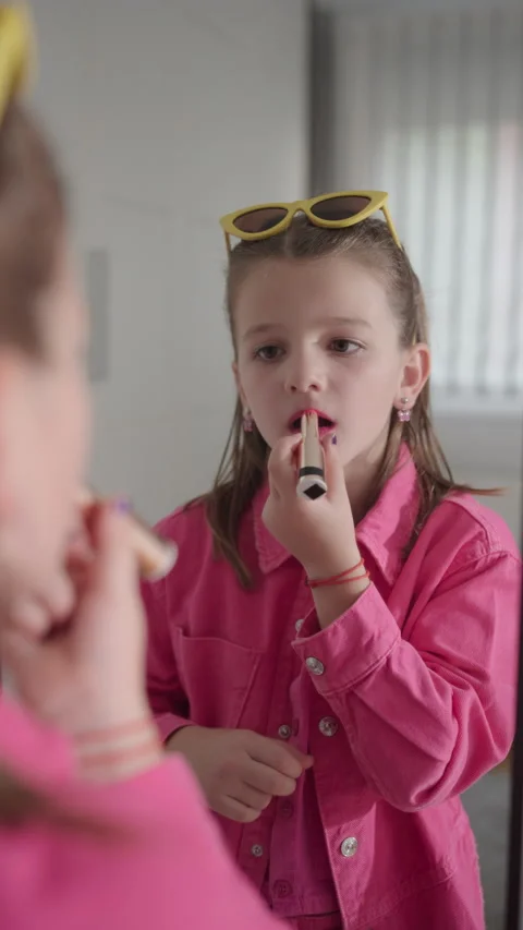 Little girl putting on lipstick in front... | Stock Video | Pond5