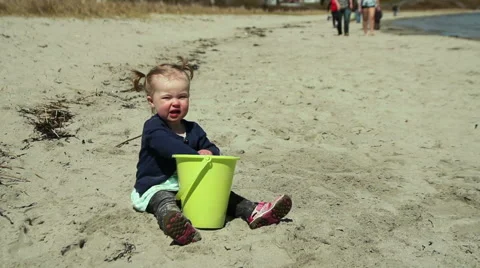 Little girl putting sand in a bucket on ... | Stock Video | Pond5