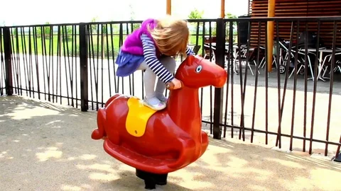 Little girl riding on rocking horse in c... | Stock Video | Pond5