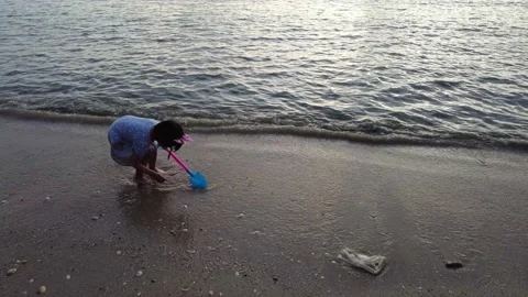 Little girl with shovel beach tool play ... | Stock Video | Pond5