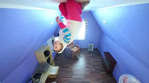 Little girl sits on ceiling upside down ... | Stock Video | Pond5
