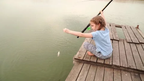little girl sits with fishing rod caught... | Stock Video | Pond5
