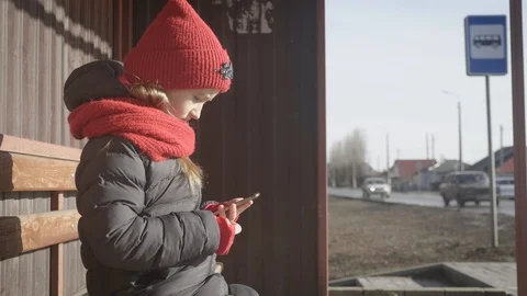 Little girl sitting on a bench waiting f... | Stock Video | Pond5