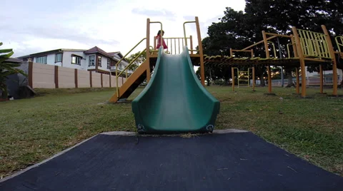 little girl slide down from a slider at ... | Stock Video | Pond5