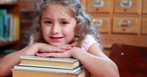 Little girl smiling at camera in the lib... | Stock Video | Pond5
