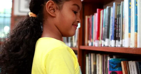 Little girl smiling at camera in the lib... | Stock Video | Pond5