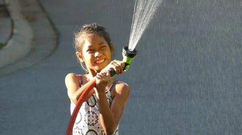Little Girl Spraying Herself With A Gard... | Stock Video | Pond5