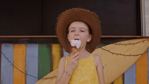 Little girl in straw hat eating ice-crea... | Stock Video | Pond5