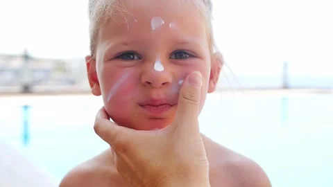 Little girl with sunscreen cream on her ... | Stock Video | Pond5
