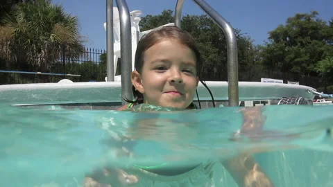 Little girl swimming in pool, half under... | Stock Video | Pond5
