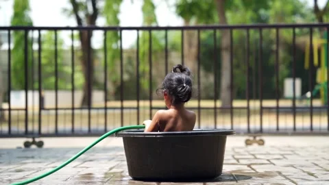 Little girl taking bath outdoor in plast... | Stock Video | Pond5