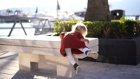 Little girl trying to climb out onto a b... | Stock Video | Pond5