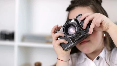 A little girl uses a retro camera, a chi... | Stock Video | Pond5