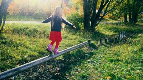 Little girl walking on a balance beam in... | Stock Video | Pond5