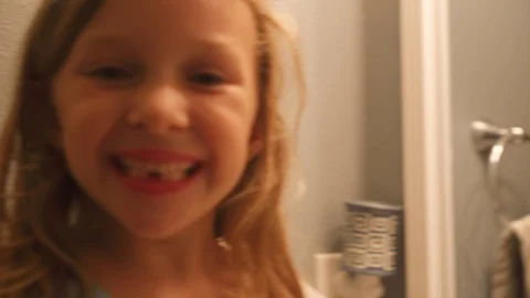 A little girl who lost two teeth smiles,... | Stock Video | Pond5