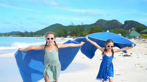 Little girls have fun with beach towel d... | Stock Video | Pond5