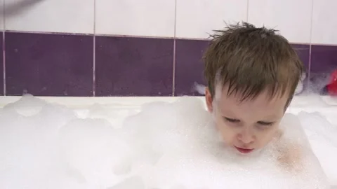 Little handsome boy bathes in a bath wit... | Stock Video | Pond5