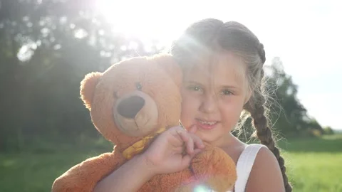 little kid girl hugging a teddy bear toy... | Stock Video | Pond5