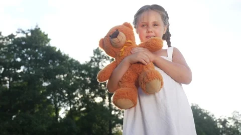 little kid girl hugging a teddy bear toy... | Stock Video | Pond5