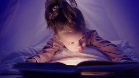 Little kid girl reading book lying in te... | Stock Video | Pond5