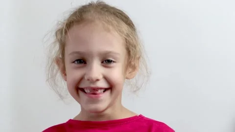 A little toothless girl smiles. Close-up... | Stock Video | Pond5