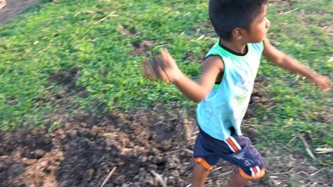 Local boy playing and throwing mud at do... | Stock Video | Pond5