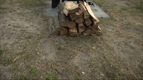 Log stack and campfire burning on campsi... | Stock Video | Pond5