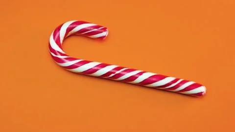Lollipop cane spinning on orange backgro... | Stock Video | Pond5