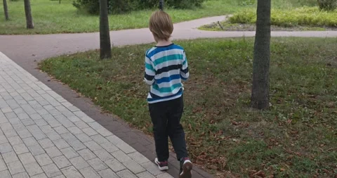 Lonely Kid Boy Walks Alone in City Park.... | Stock Video | Pond5