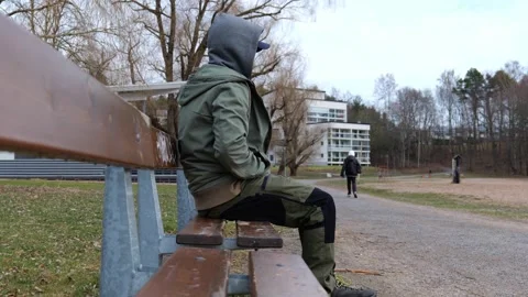 Lonely man in a hood sitting down on a p... | Stock Video | Pond5
