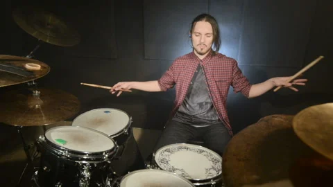 A long-haired drummer sitting at the dru... | Stock Video | Pond5